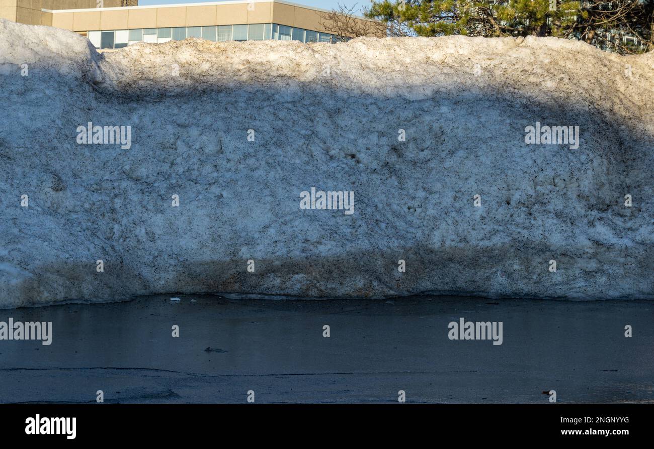 Heap of accumulated snow plowed and moved to side of road after days of ...