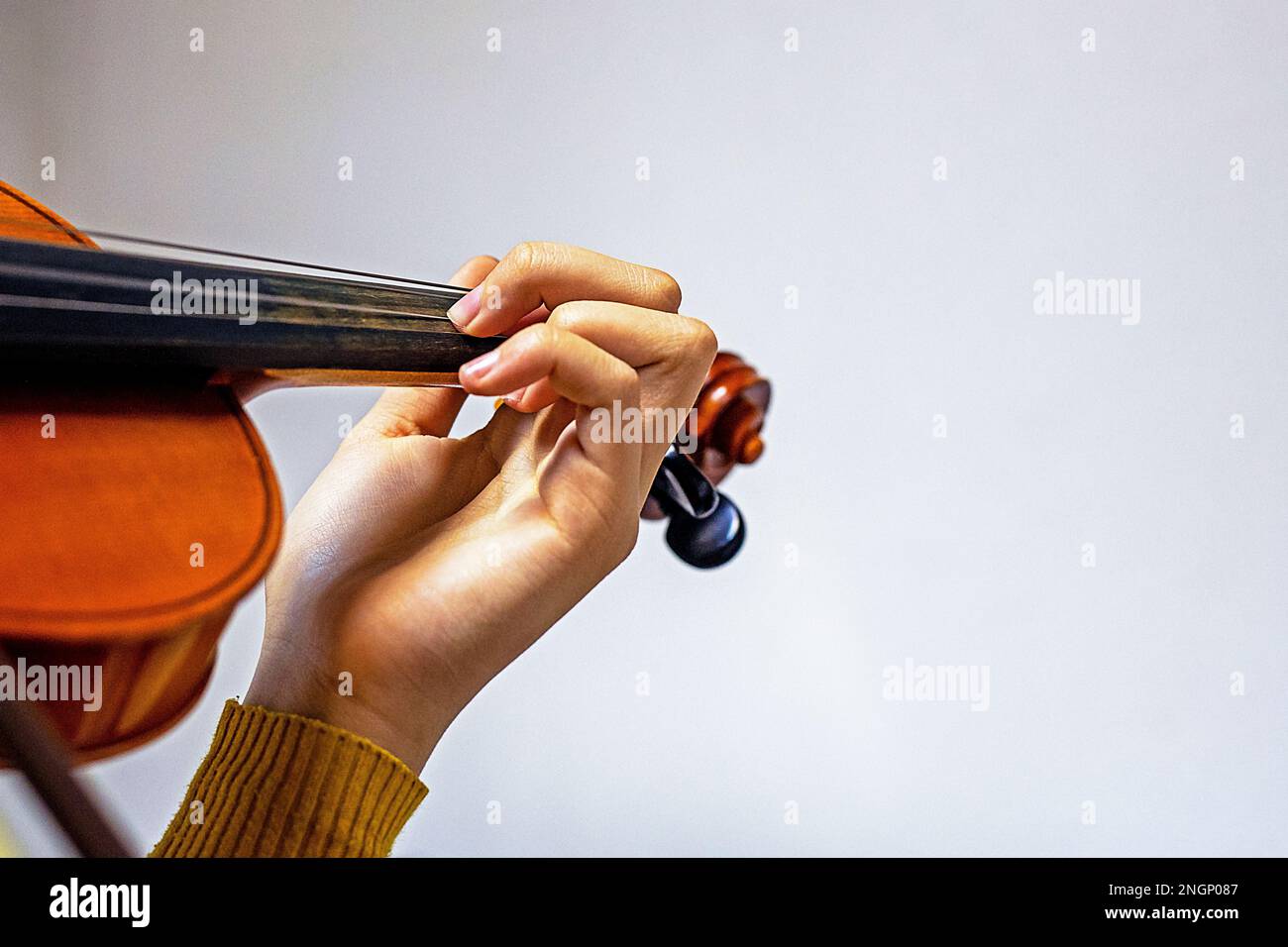 training the left hand on the strings on the student's violin. Musical ...