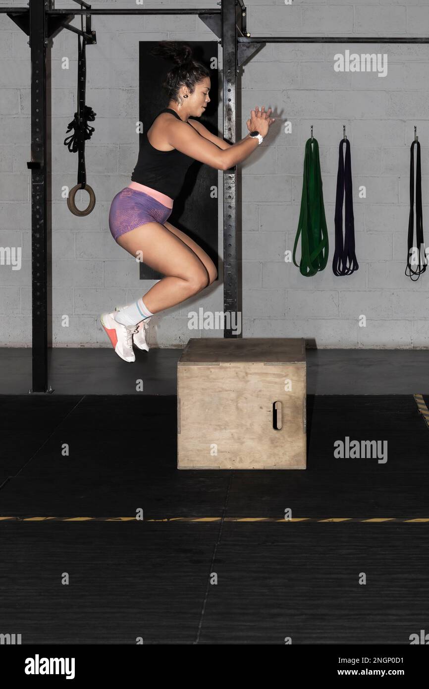 woman jumping on a box as part of exercise routine. Fitness woman doing ...
