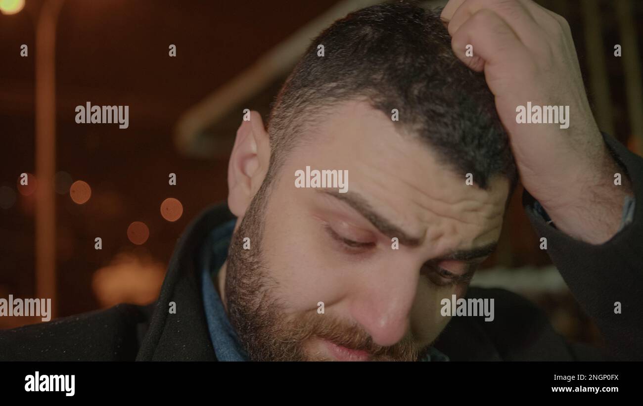 Somber and intense young man with a thick beard speaks via video call ...