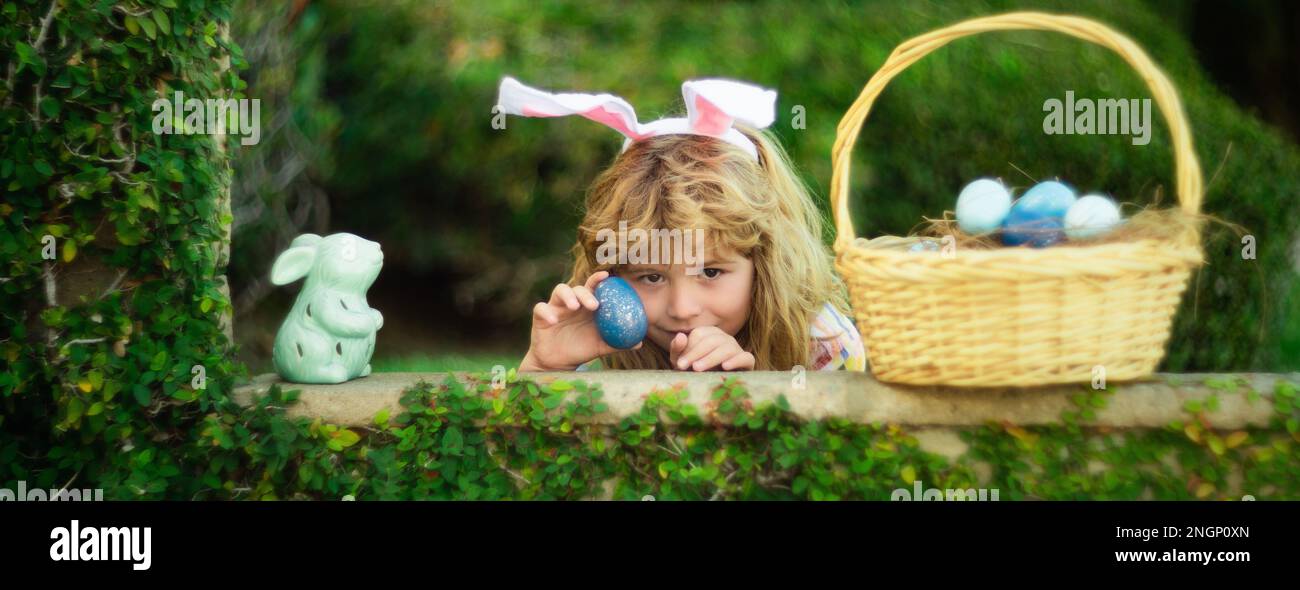 Child with rabbit ears, Easter holidays. Kid hunting Easter eggs in ...