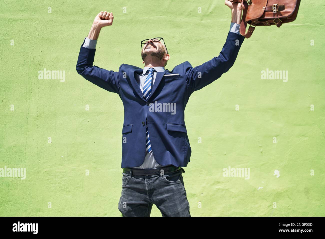 Young hispanic man executive smiling confident dancing over green ...