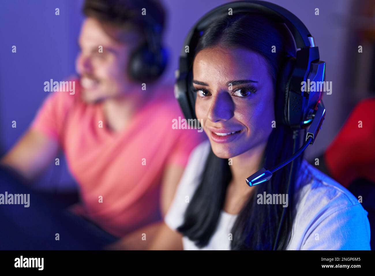 Man and woman streamers playing video game using computer at gaming ...