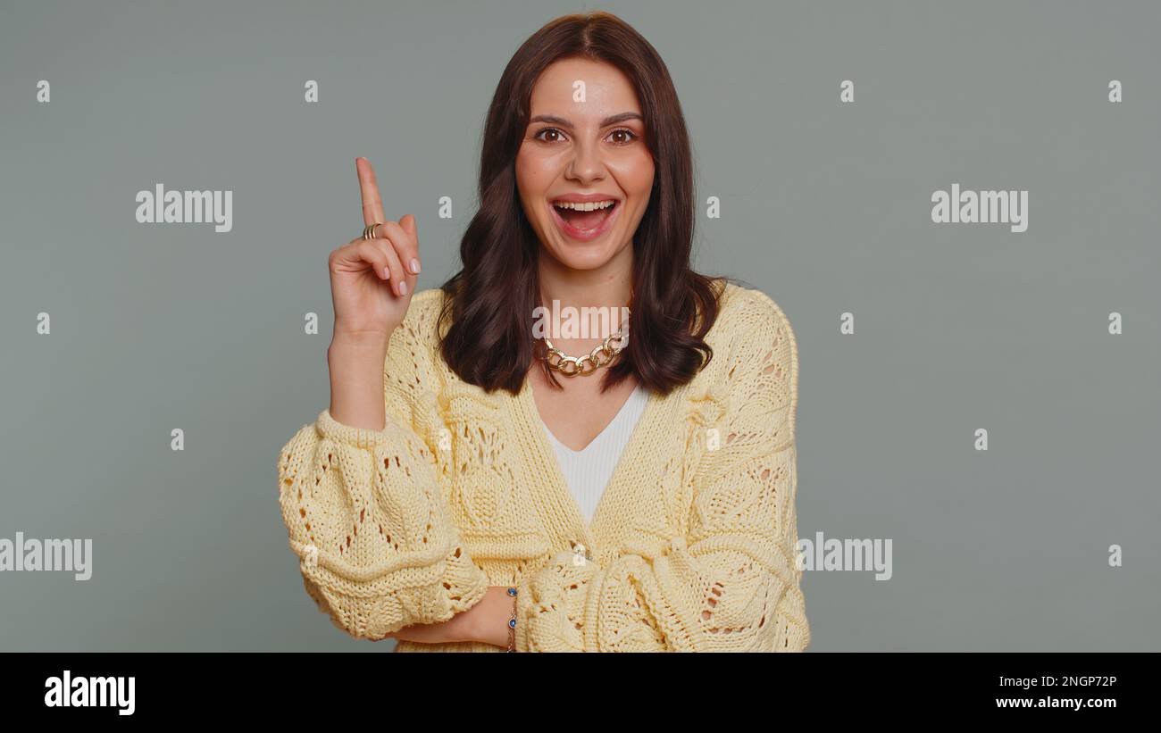 Eureka. Inspired pretty woman pointing finger up with open mouth ...