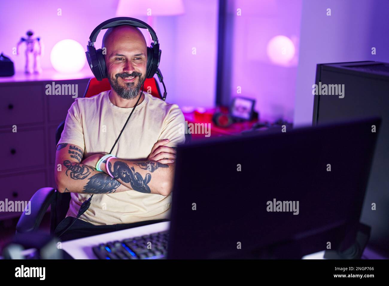 Young bald man streamer smiling confident sitting with arms crossed ...