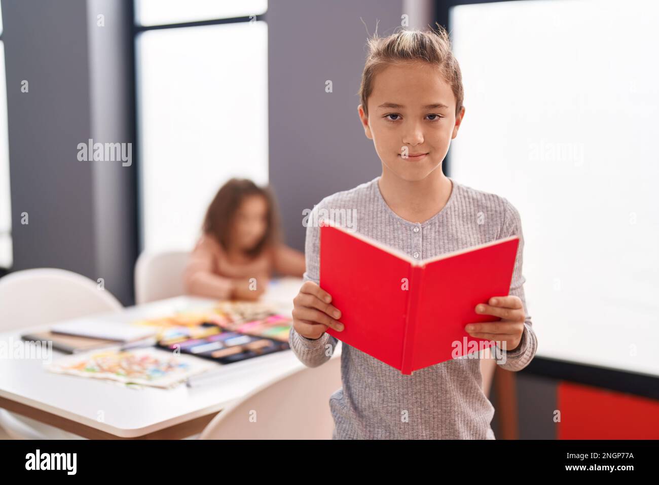 Two kids students reading book studying at classroom Stock Photo - Alamy