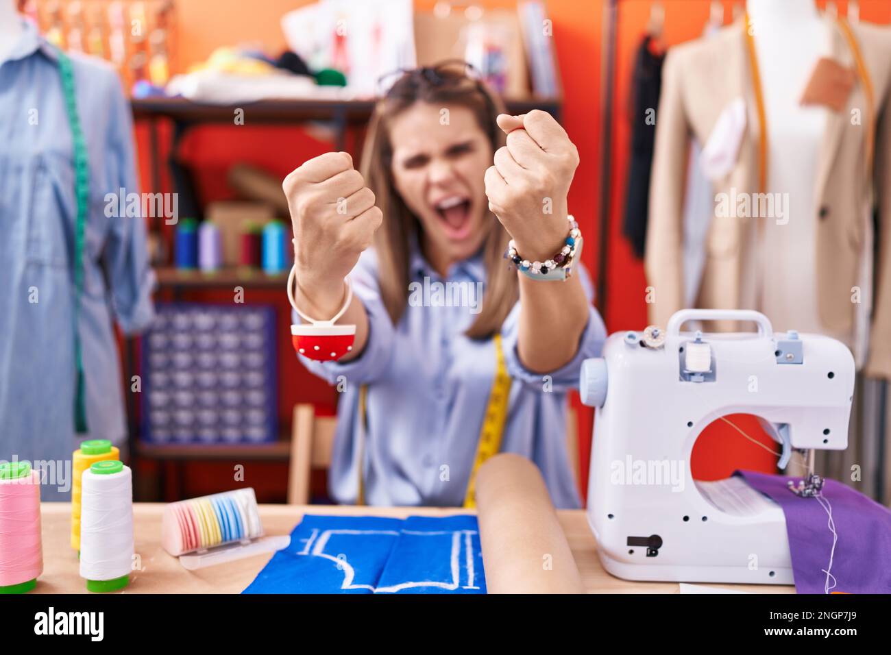 Hispanic young woman dressmaker designer at atelier room angry and mad ...