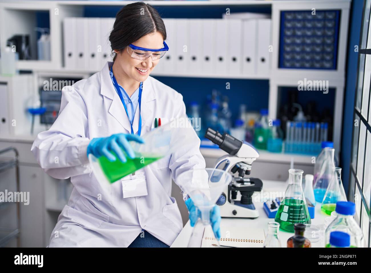 Young woman scientist measuring liquid at laboratory Stock Photo - Alamy
