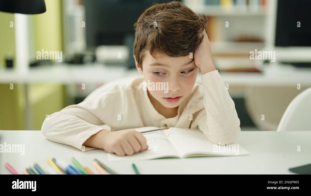 Hispanic boy reading book classroom hi-res stock photography and images ...