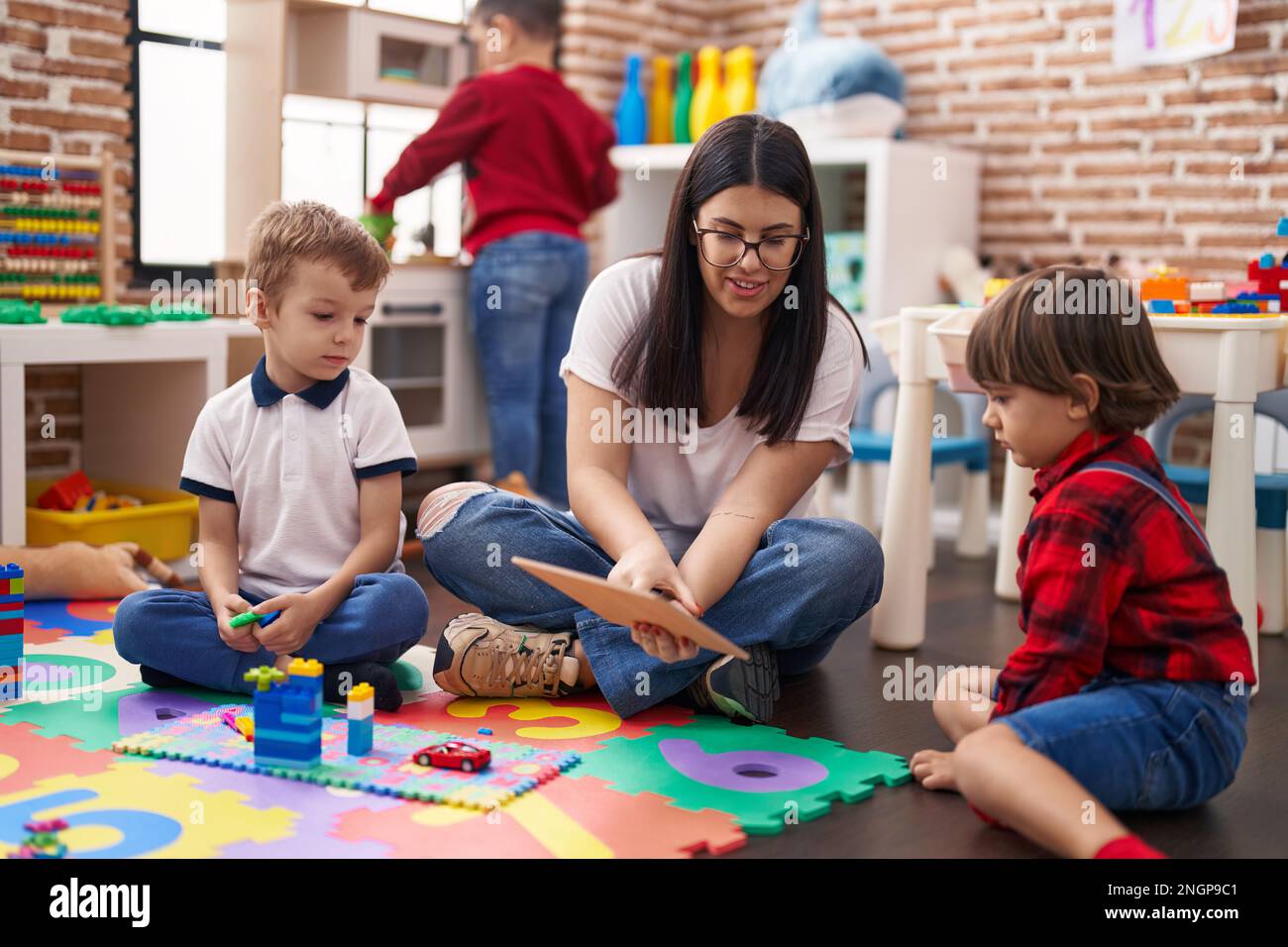 Teacher with group of boys sitting on floor having lesson at ...