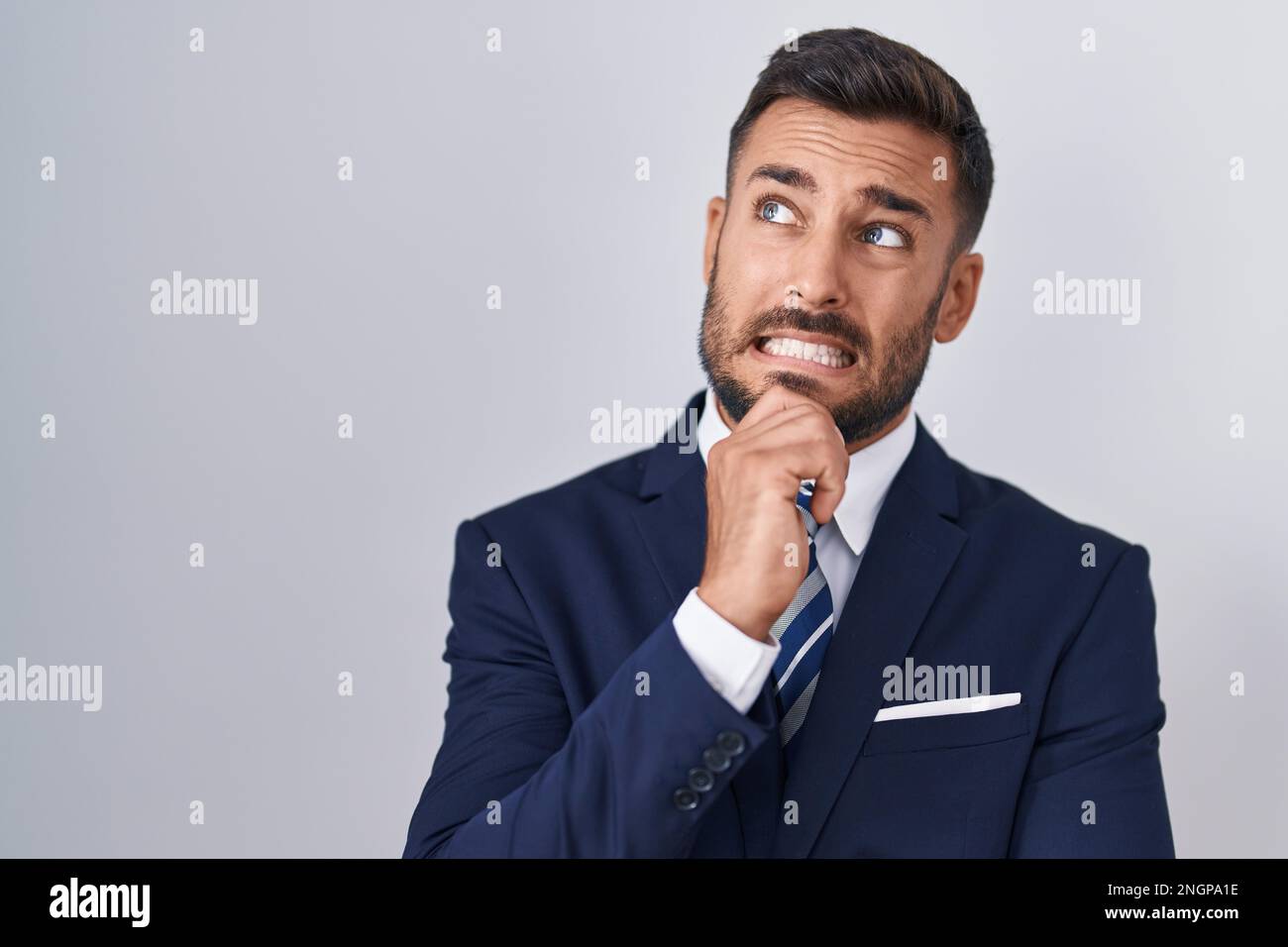 Handsome hispanic man wearing suit and tie thinking worried about a ...