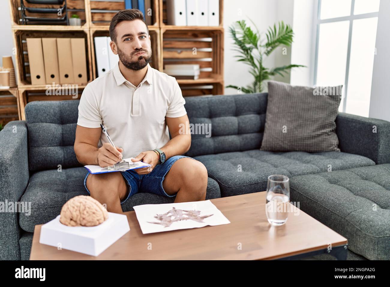 Handsome hispanic man working with rorschach test at psychology clinic ...