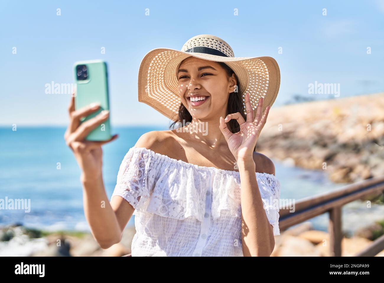Young brazilian woman taking a selfie photo with smartphone outdoors ...
