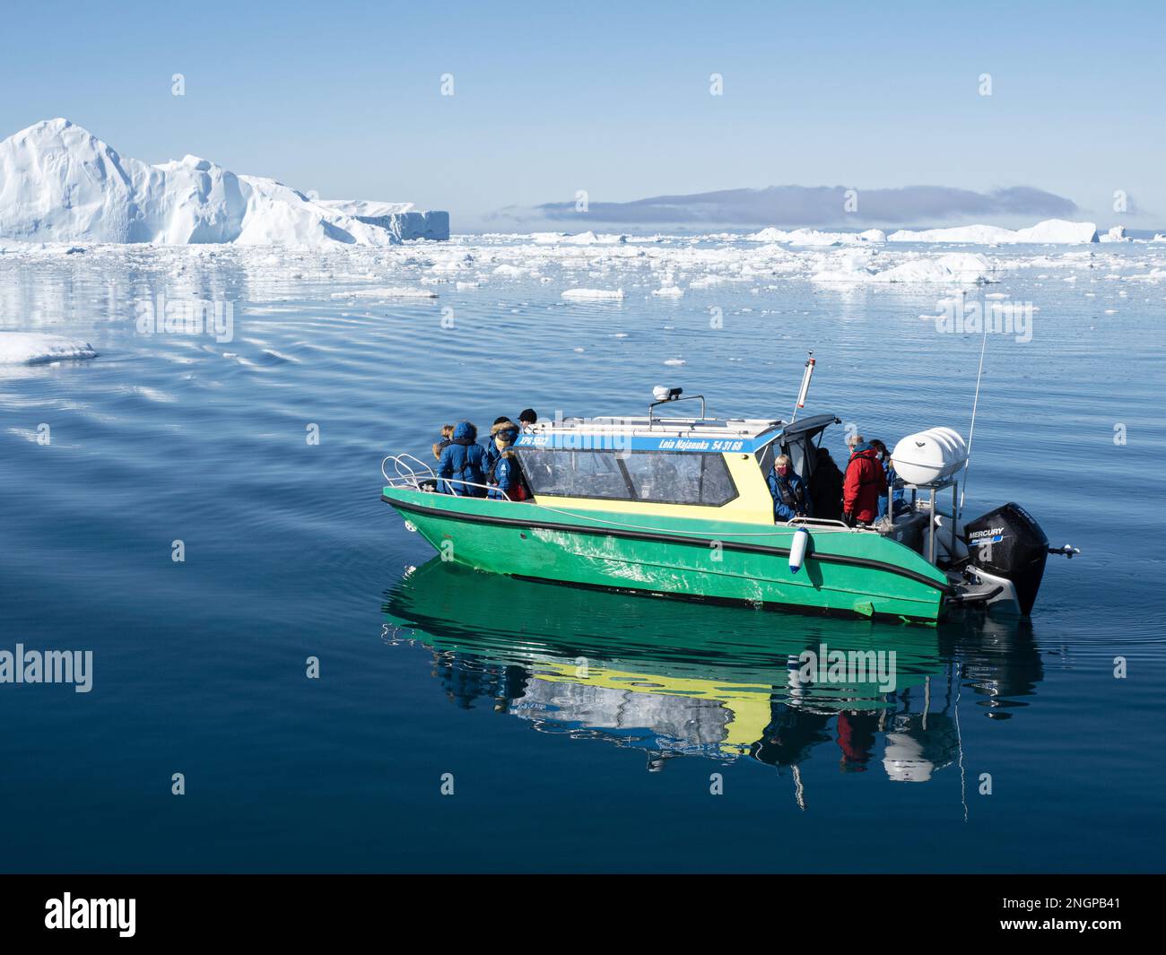 Tourists taking an ice tour in a small boat watching icebergs from the ...