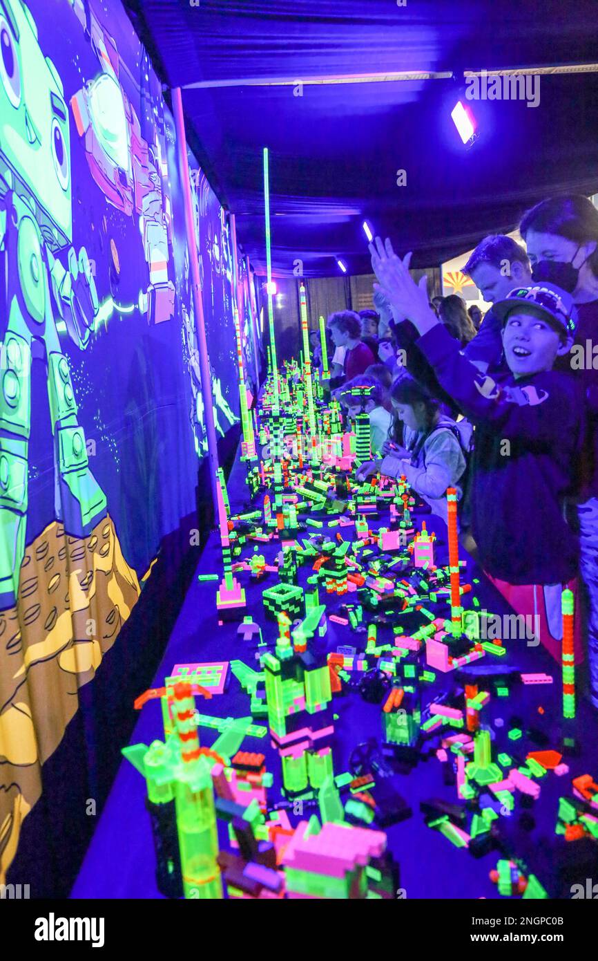 Kids and adults assemble glow in the dark LEGO creations during Brick ...