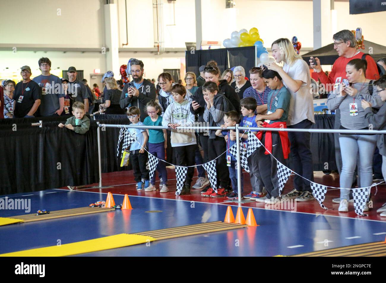 Kids and adults that assembled LEGO race cars watch them race at the ...