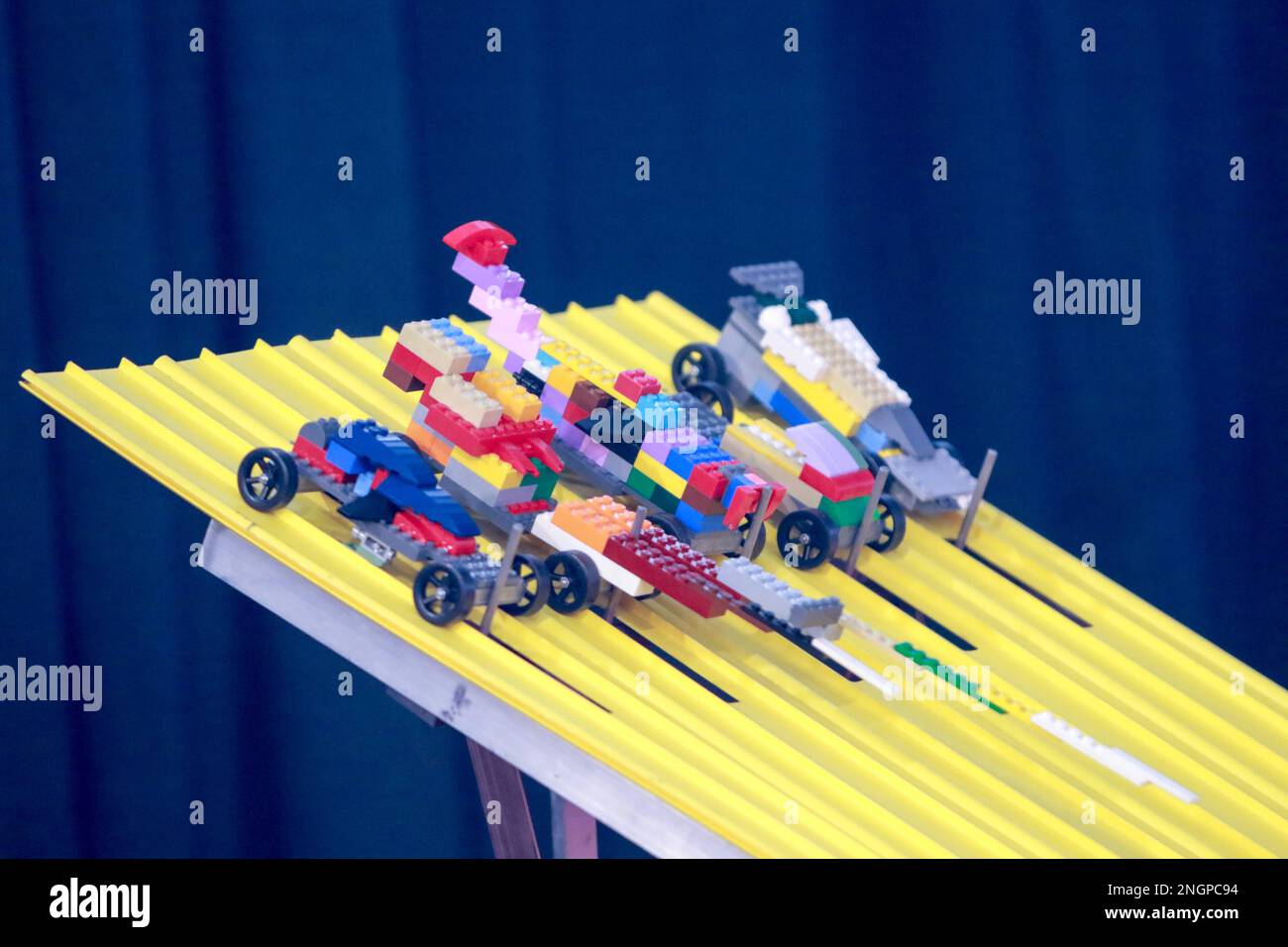Kids and adults that assembled LEGO race cars watch them race at the ...