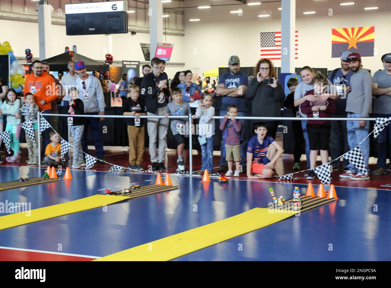 Kids and adults that assembled LEGO race cars watch them race at the ...
