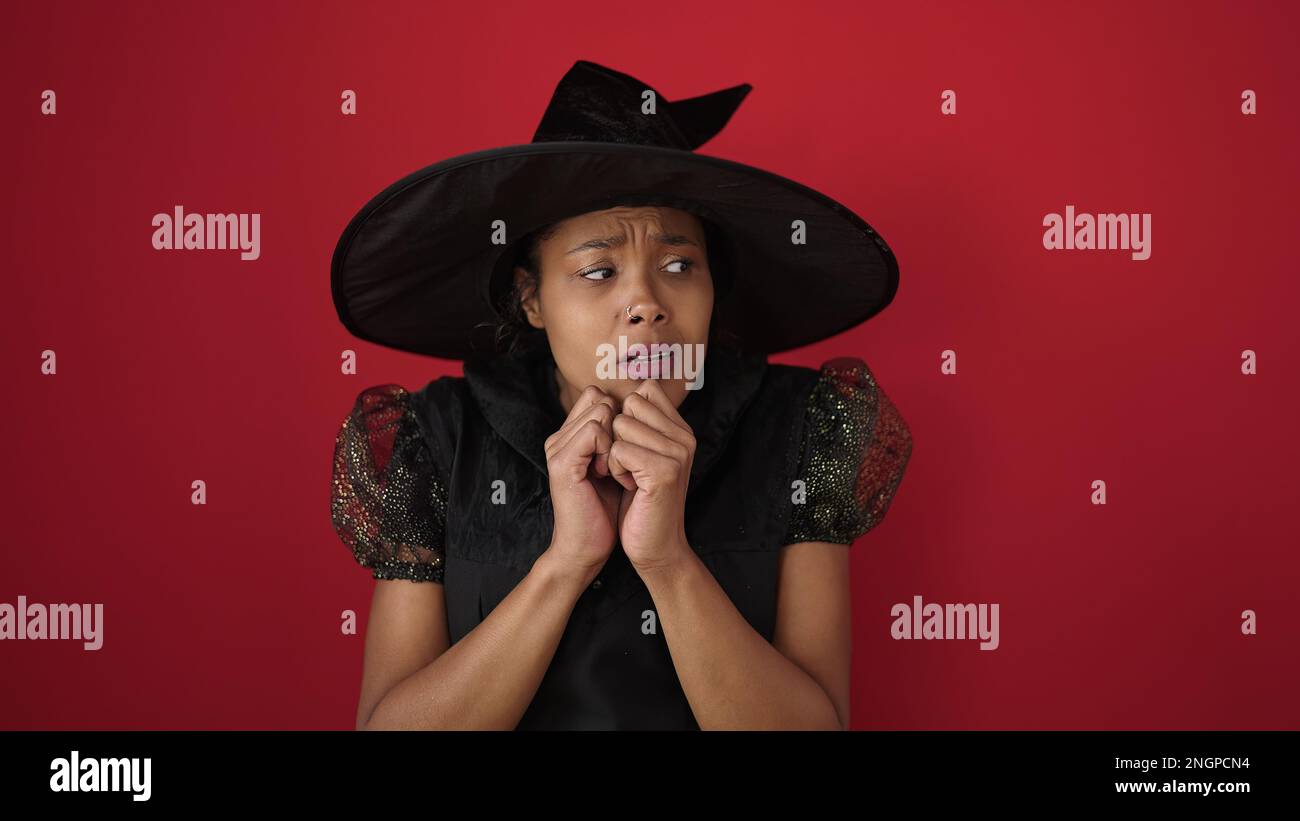 African american woman wearing witch costume doing fear gesture over ...