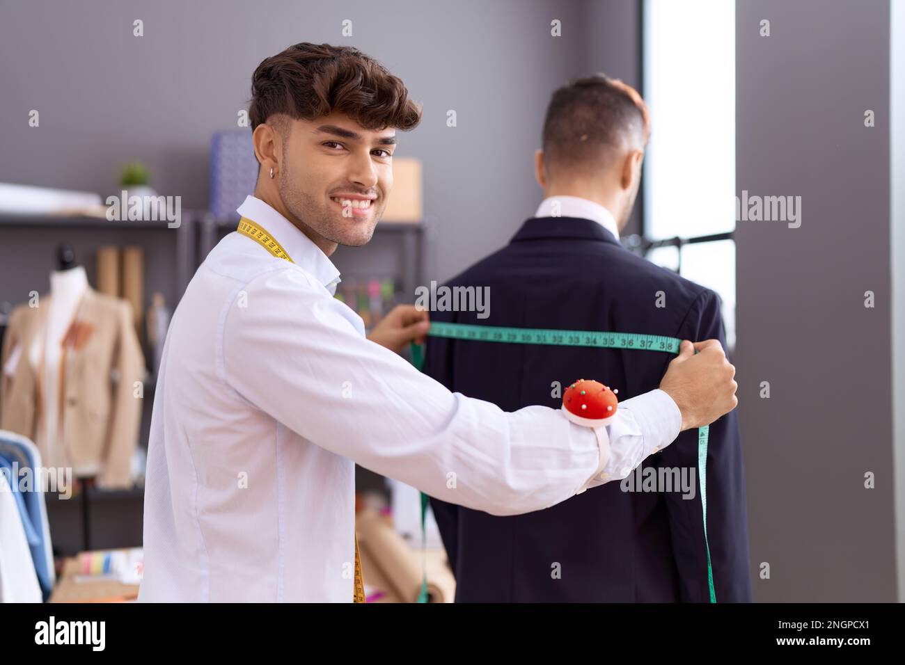 Two hispanic men tailor measuring back client at atelier Stock Photo ...