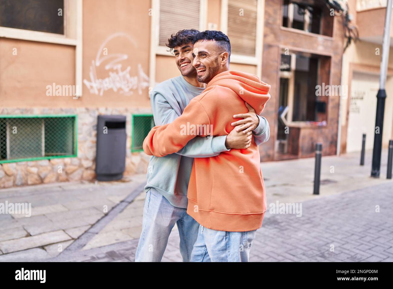 Two man couple hugging each other standing at street Stock Photo - Alamy