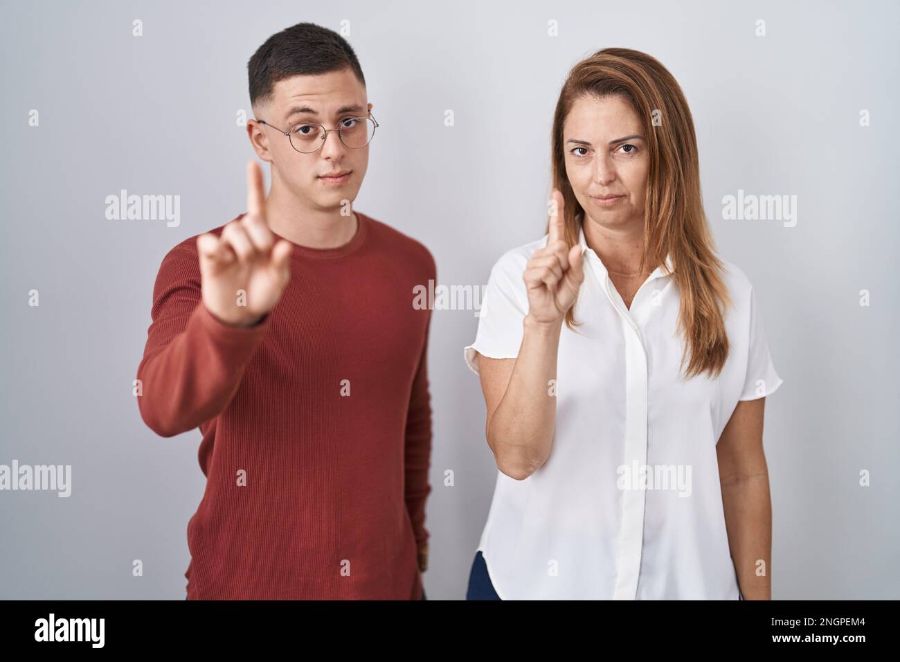 Mother and son standing together over isolated background pointing with ...