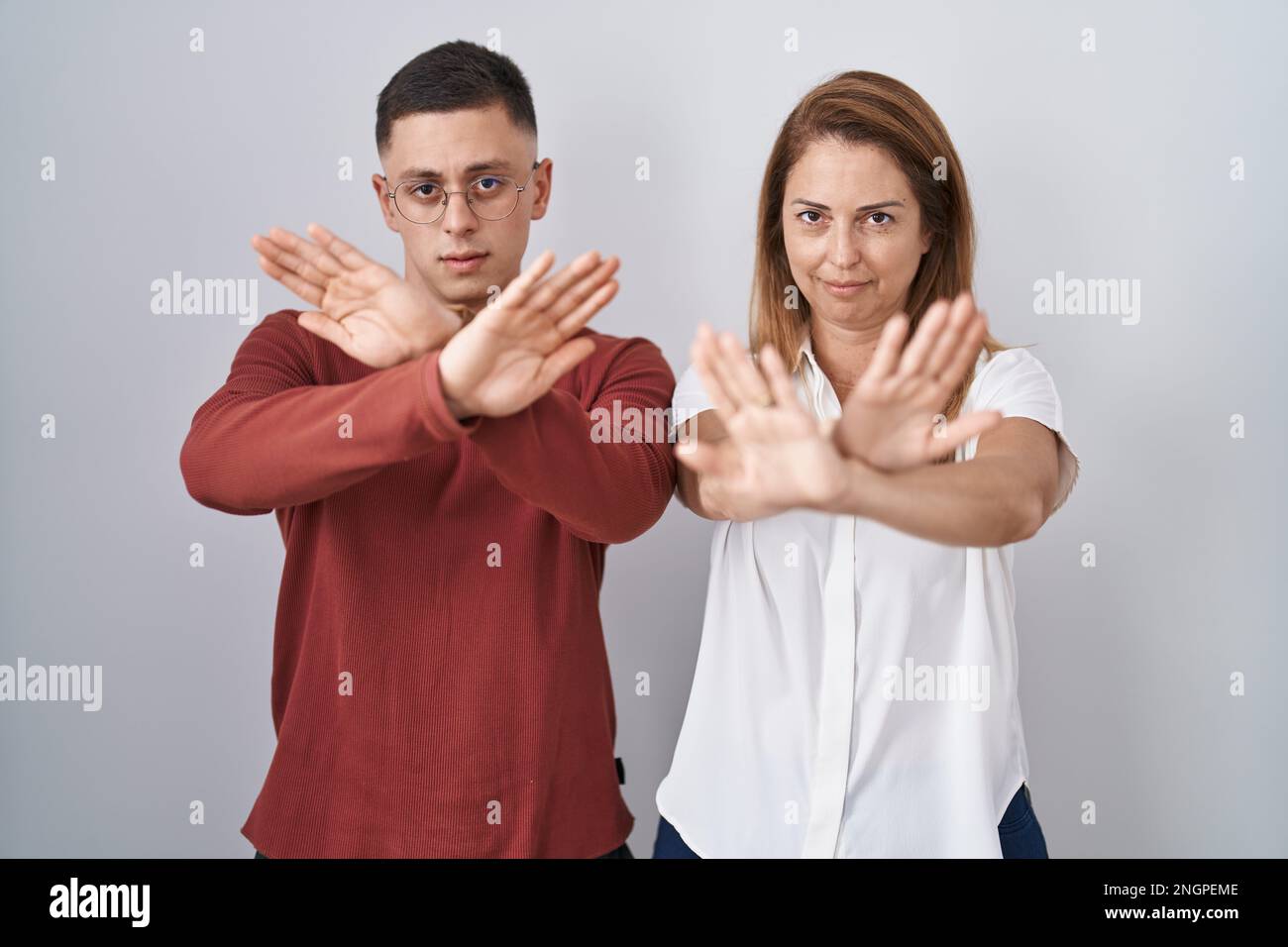 Mother and son standing together over isolated background rejection ...