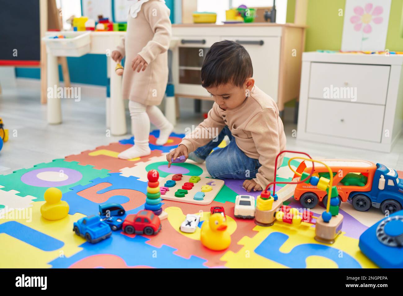 Two kids playing with maths puzzle game sitting on floor at ...
