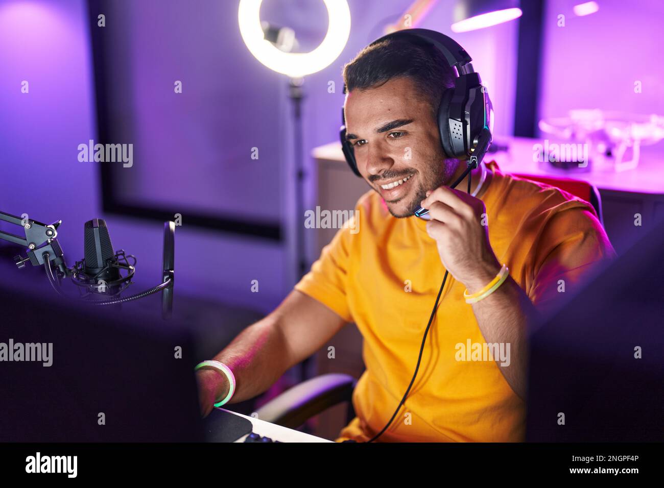 Young hispanic man streamer playing video game using computer at gaming ...