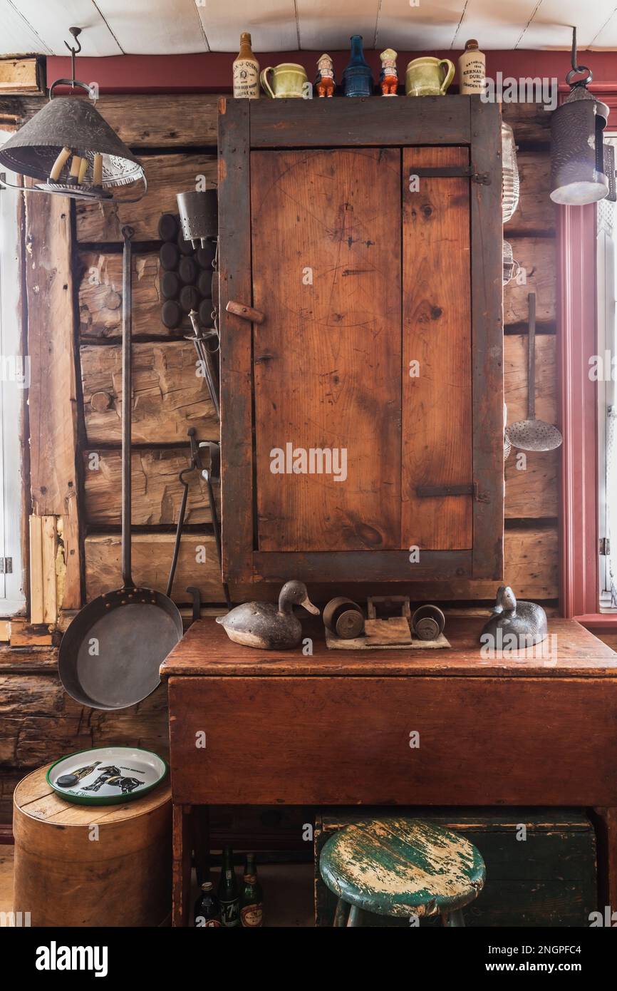 Antique cast iron pan with long handle hanging from piece sur piece log ...