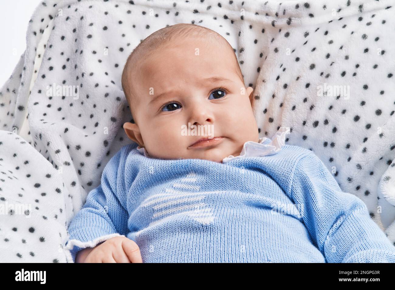 Adorable baby relaxed lying on sofa over white isolated background ...