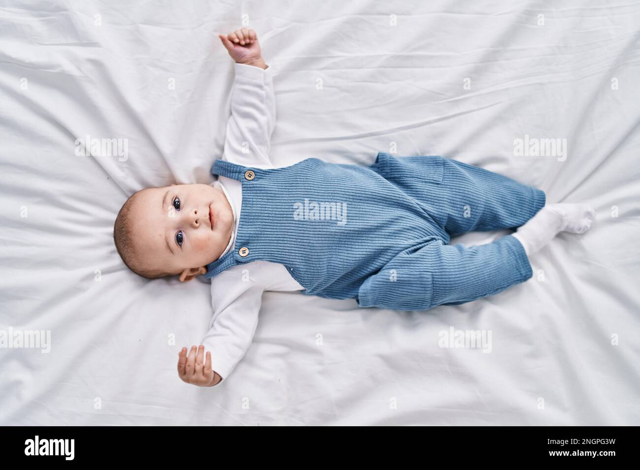 Adorable baby relaxed lying on bed at bedroom Stock Photo - Alamy
