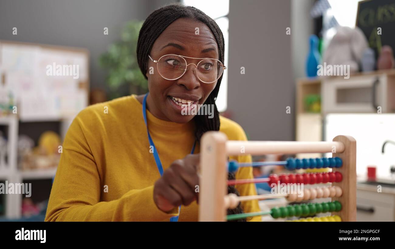 African woman working as teacher teaching maths with abacus at ...
