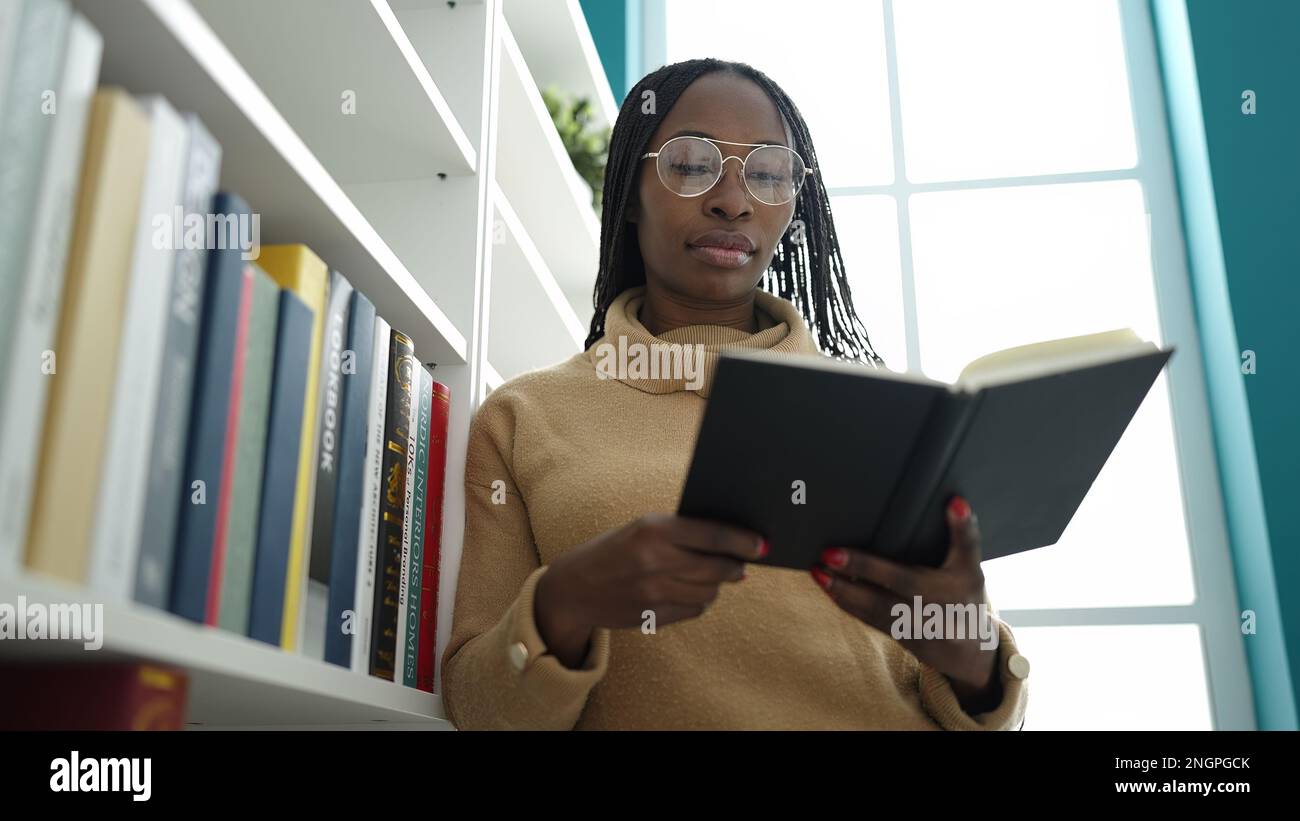 African woman reading a book at library university Stock Photo - Alamy