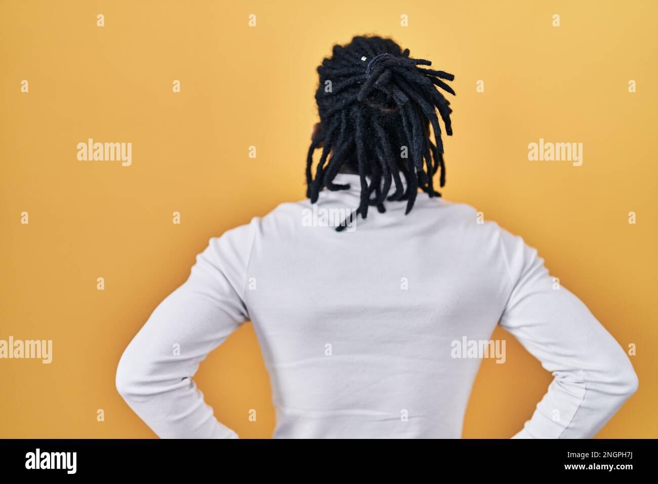 African man with dreadlocks wearing turtleneck sweater over yellow ...