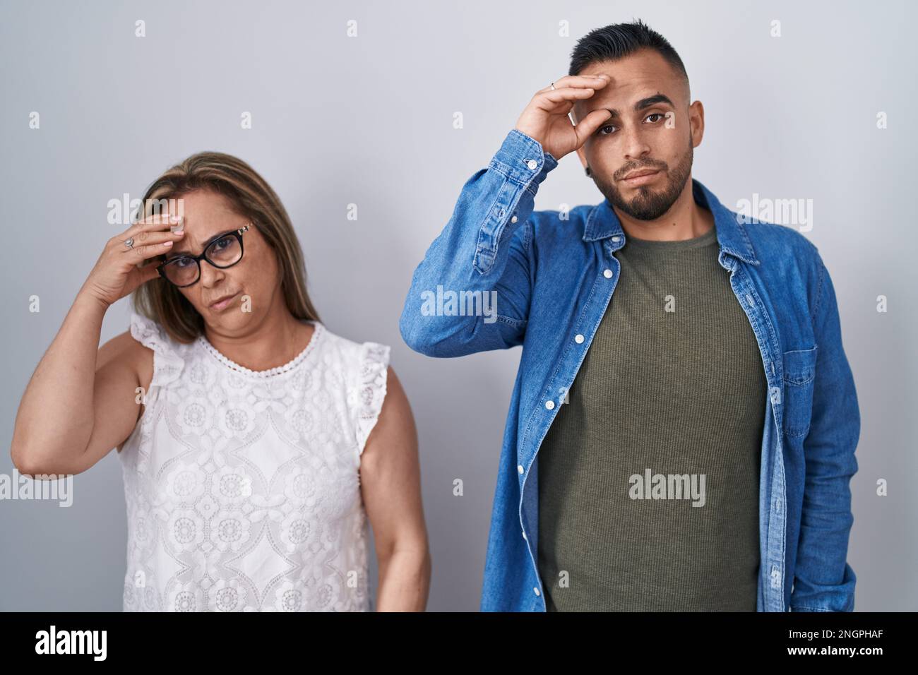 Hispanic mother and son standing together worried and stressed about a ...