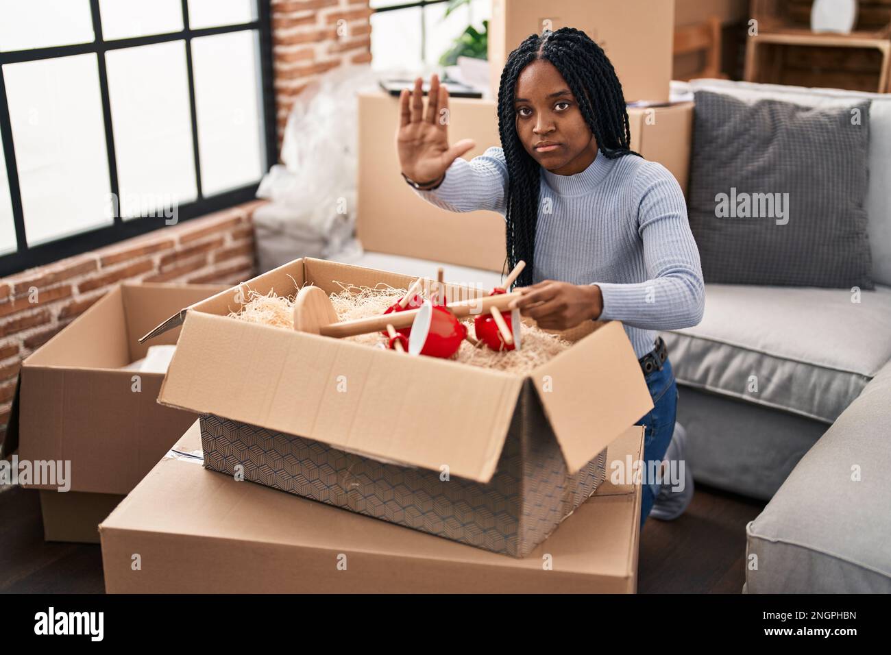 African american woman moving to a new home opening boxes with open ...