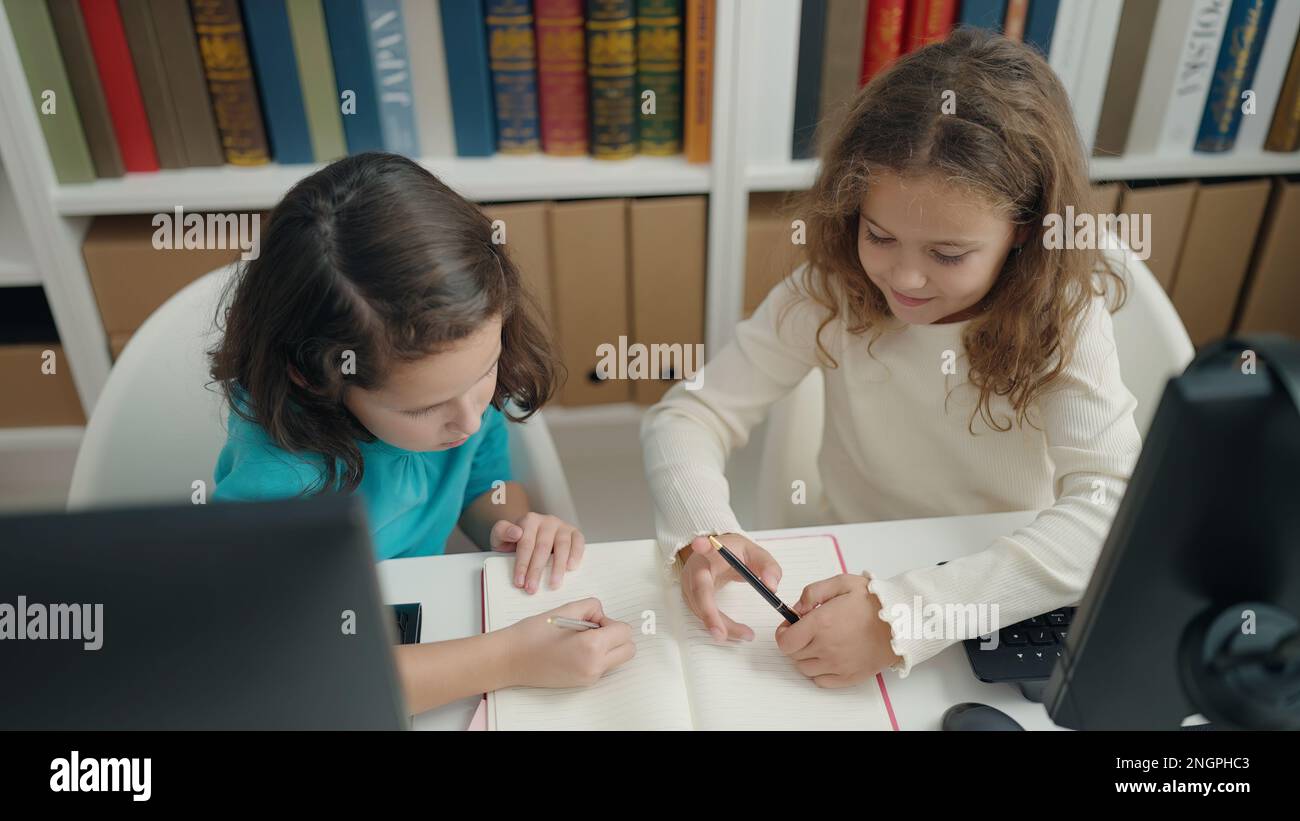 Two kids students using computer writing on notebook at classroom Stock ...