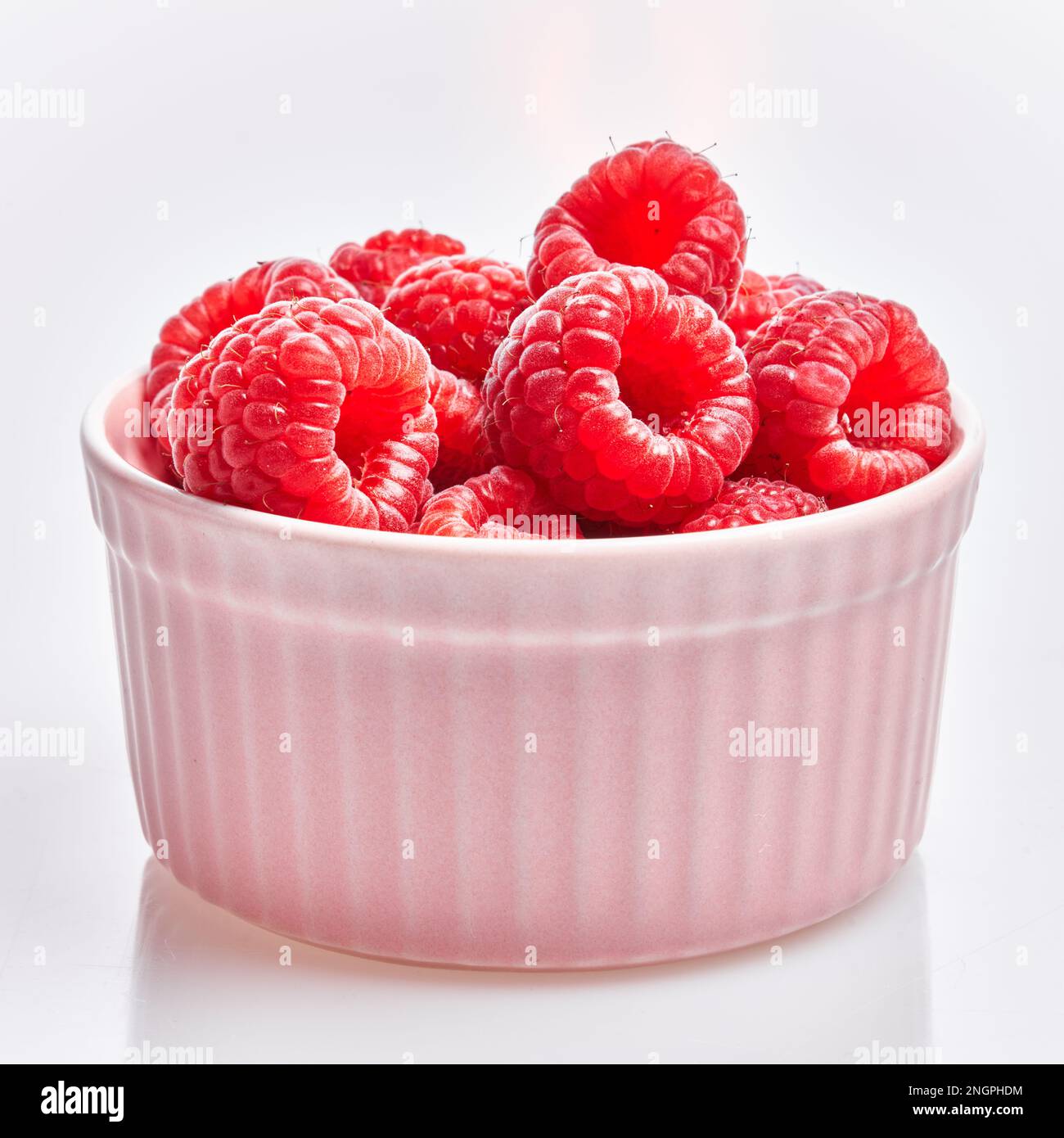 Delicious group of raspberries on ceramic bowl over isolated white ...