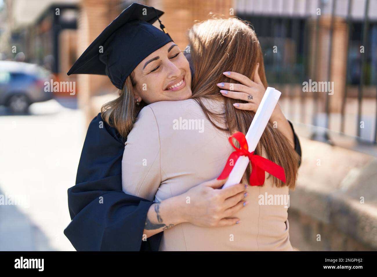 Mother and daughter hugging each other celebrating graduation at ...