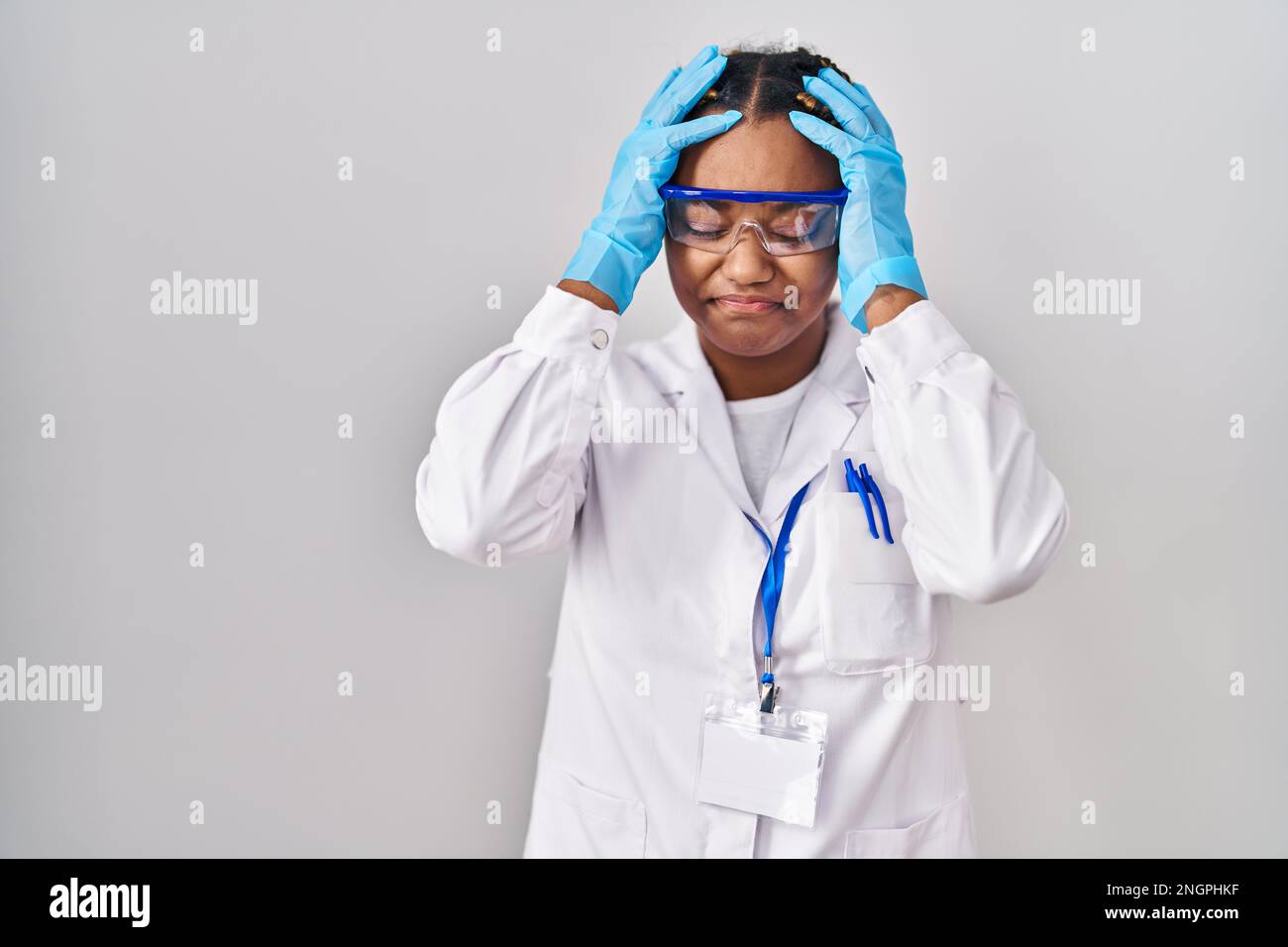 African american woman with braids wearing scientist robe suffering ...