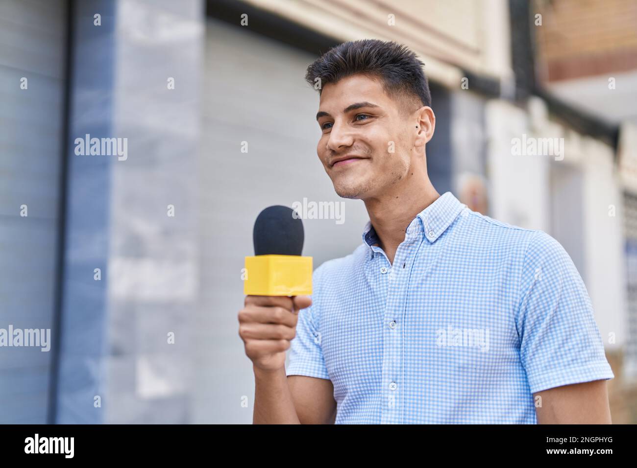 Young hispanic man reporter working using microphone at street Stock Photo - Alamy