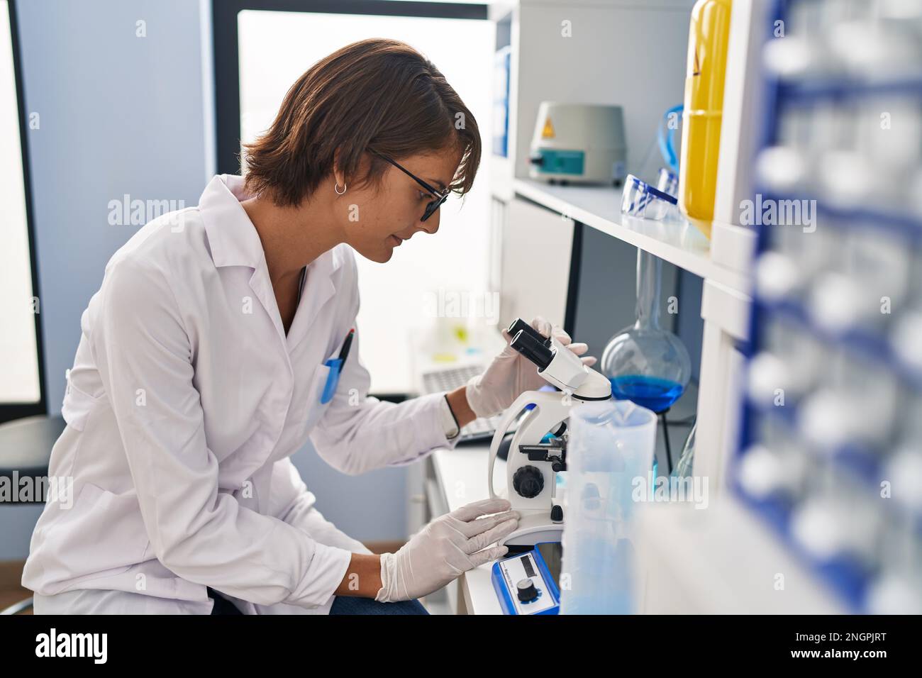 Young beautiful hispanic woman scientist using microscope at laboratory Stock Photo - Alamy