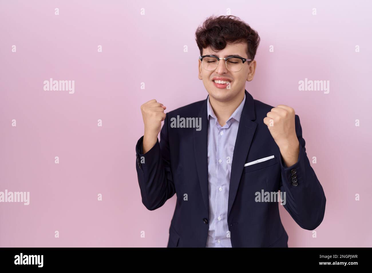 Young non binary man with beard wearing suit and tie very happy and ...