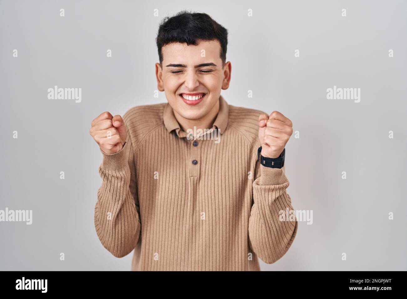 Non binary person standing over isolated background excited for success ...