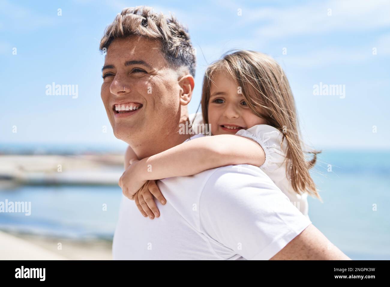 Father and daughter smiling confident hugging each other holding on back at seaside Stock Photo ...