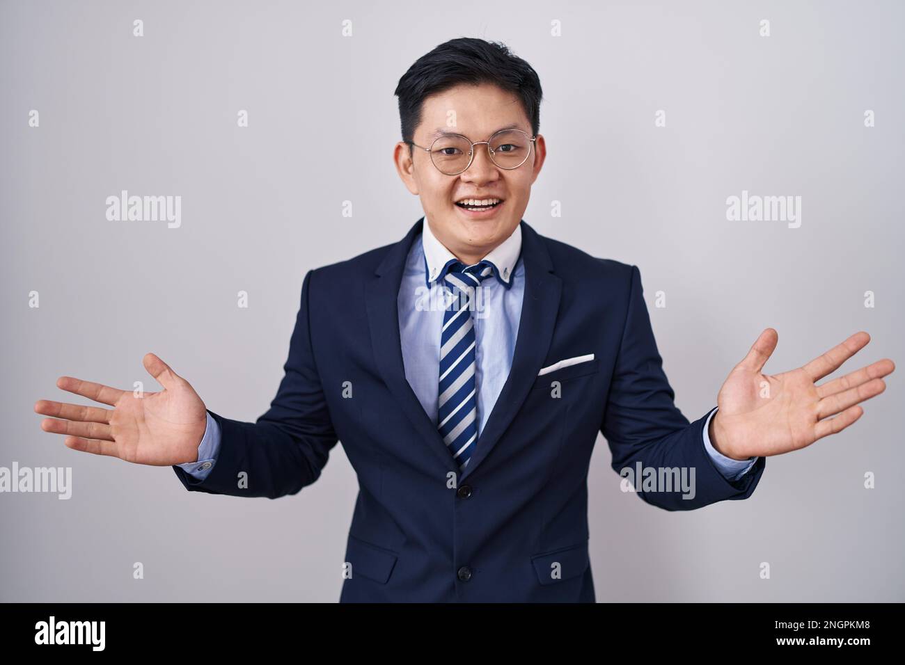 Young asian man wearing business suit and tie celebrating crazy and ...