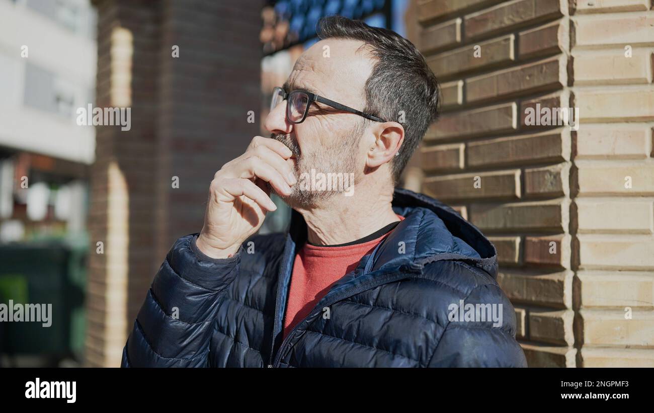 Middle age man standing with doubt expression at street Stock Photo - Alamy