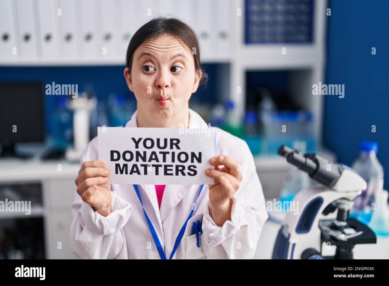 Woman with down syndrome working at scientist laboratory holding your ...