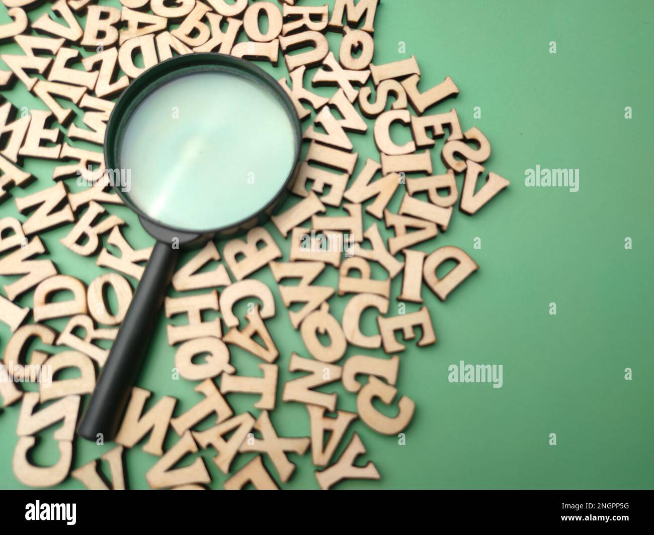 Wooden word and magnifying glass on a green background. Business ...